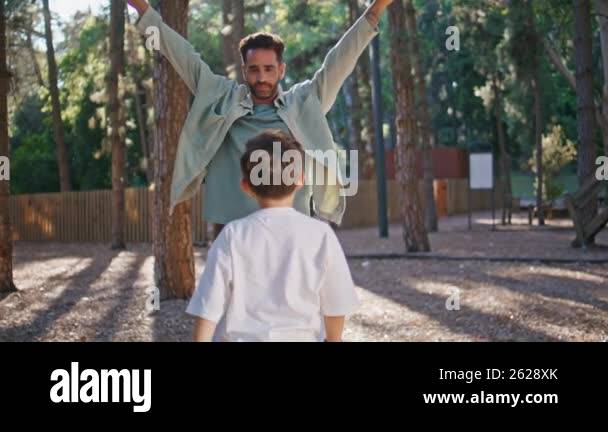 Father son enjoying game at park playfully raising hands closeup ...