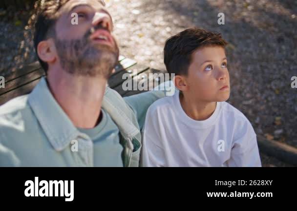 Child dad sitting bench looking distance enjoy conversation closeup ...