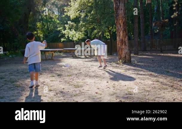 Happy family playing frisbee in summer park. Young parent active child throwing each other disc ...