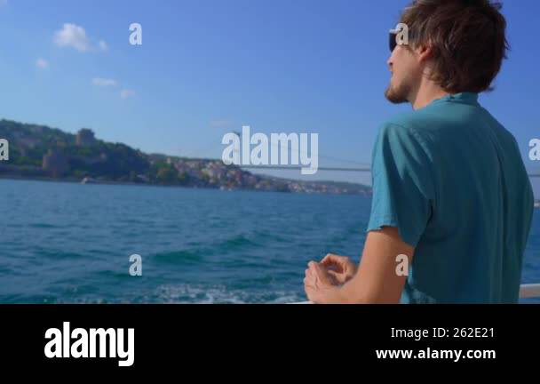 Young man enjoying the view while traveling on a boat along the ...