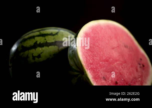 Delicious and juicy watermelons, one split in half and one whole, on a ...