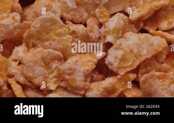 Cereal-covered surface of sugar-coated corn flakes, seen in a very ...