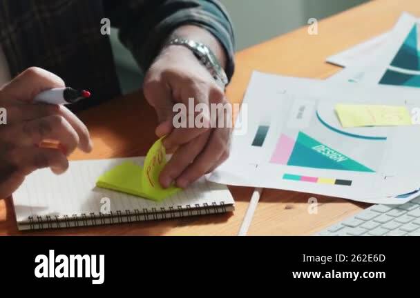 Professional designer writing and designing logo graphic at meeting ...