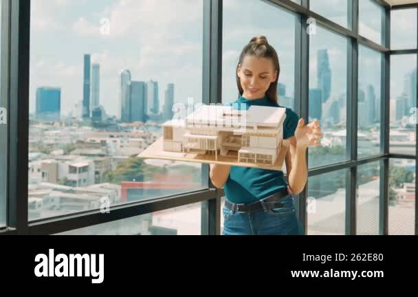 Young happy beautiful engineer check house model by turning left side ...