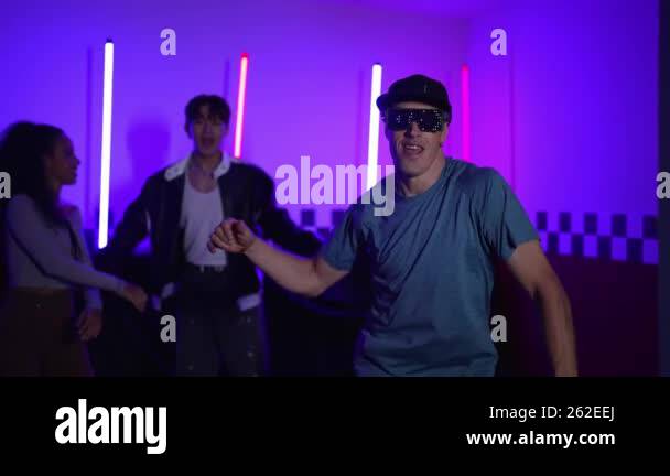 Skilled break dancer dancing in front of camera while diverse friend ...