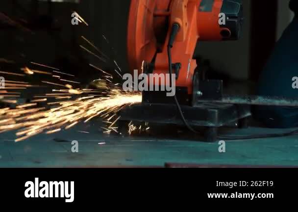 Professional mechanic is cutting steel metal with rotating diamond ...