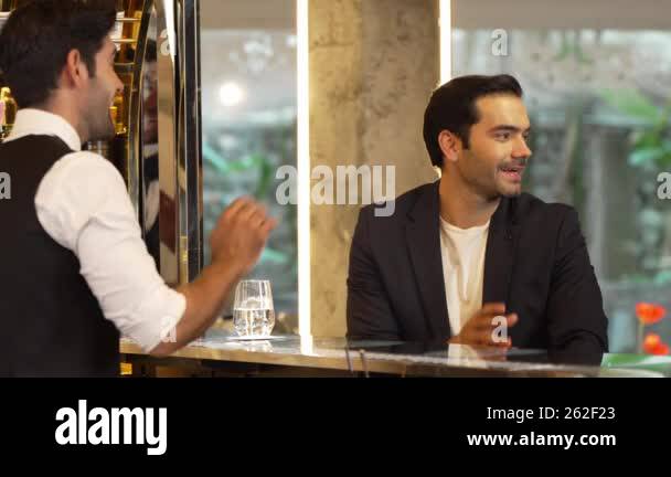 Smiling smart VIP customer inviting friend or couple for sitting at ...