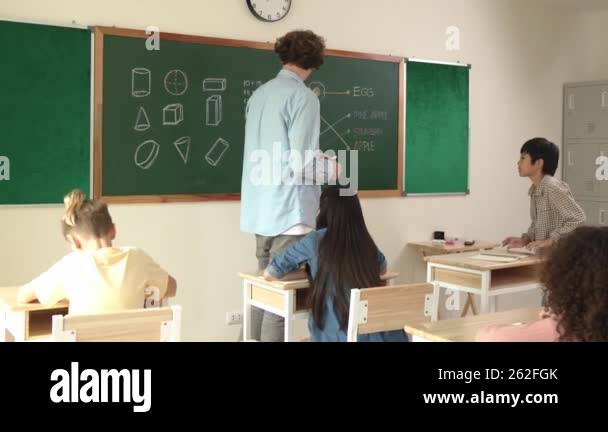 Asian boy finish writing answer while teacher clapping hands to ...