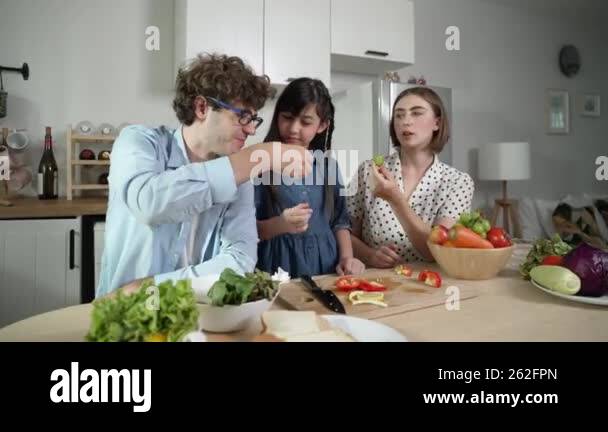 Attractive caucasian father and mother spend time together to cook ...
