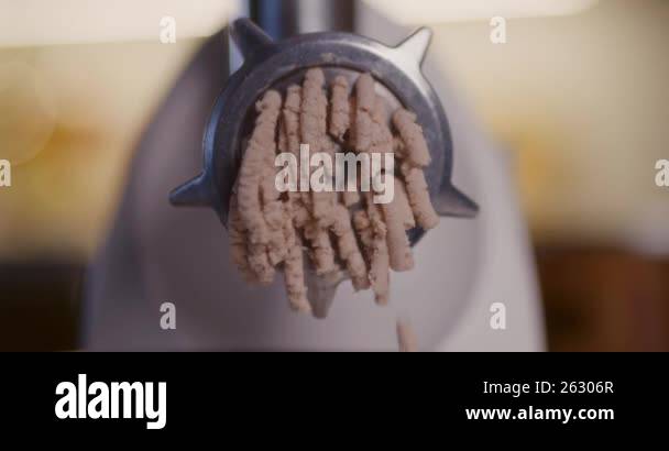 An electric grinder processes raw meat, preparing it for a meal Stock ...
