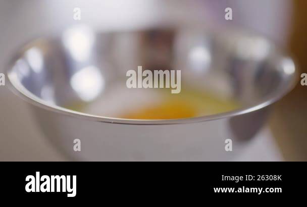 A detailed view of raw eggs nestled in flour within a mixing bowl Stock Video Footage - Alamy
