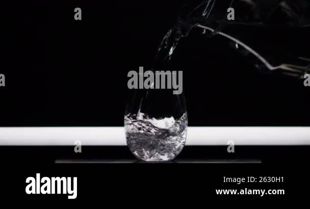 Water is streamed into a clear glass, creating a refreshing and clean visual of hydration Stock ...