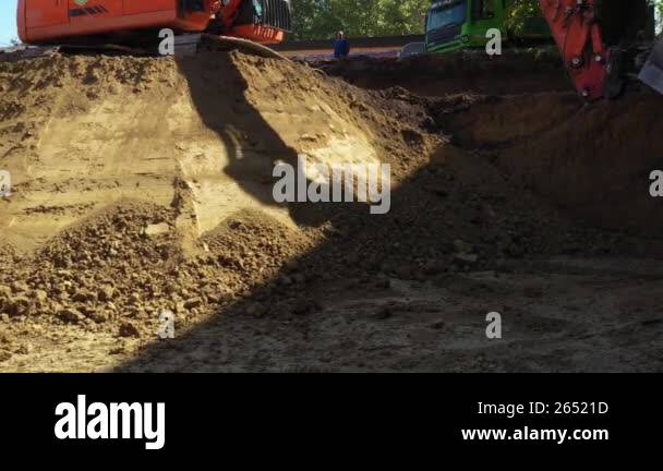Low view on excavator's work tool, blade as digging, excavating foundation for new residential ...