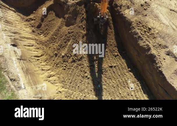 Above view on excavator's work tool, blade as digging, excavating foundation for new residential ...