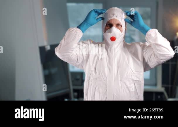 Close-up portrait of a medical worker in a protective suit, goggles and ...