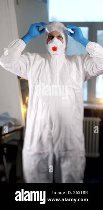 Close-up portrait of a medical worker in a protective suit, goggles and ...