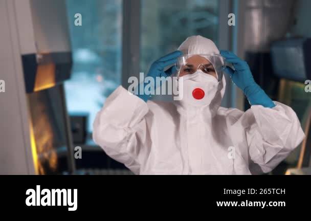 Close-up portrait of a medical worker in a protective suit, goggles and ...