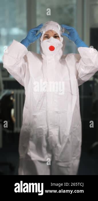 Close-up portrait of a medical worker in a protective suit, goggles and ...