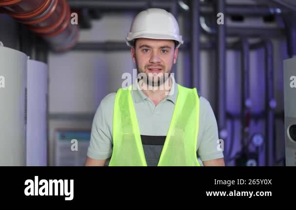 Confident male engineer in boiler room with pipelines. Professional ...