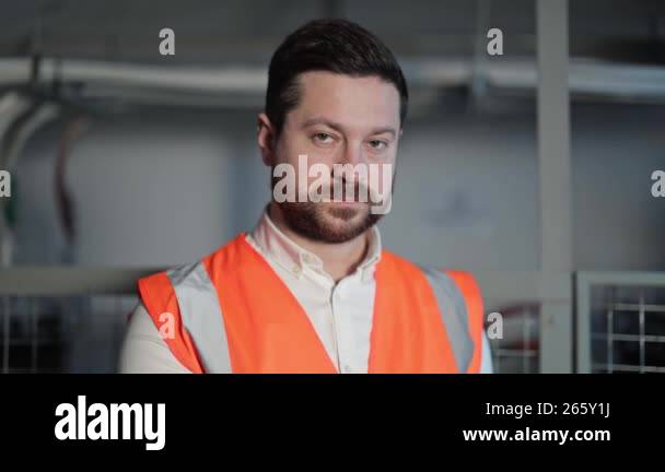 Confident electrical engineer smiles at the camera in server room ...