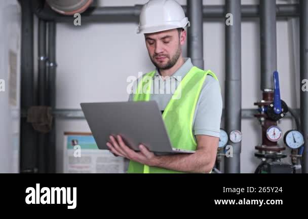 Caucasian male boiler room worker in safety vest and hardhat ...