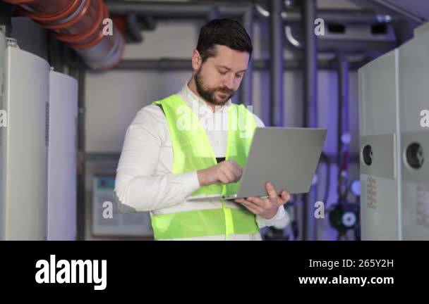 Industrial HVAC engineer using laptop in boiler room. Professional ...