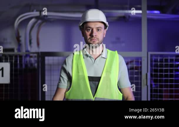 Serious electrical engineer with arms crossed in server room. Confident ...
