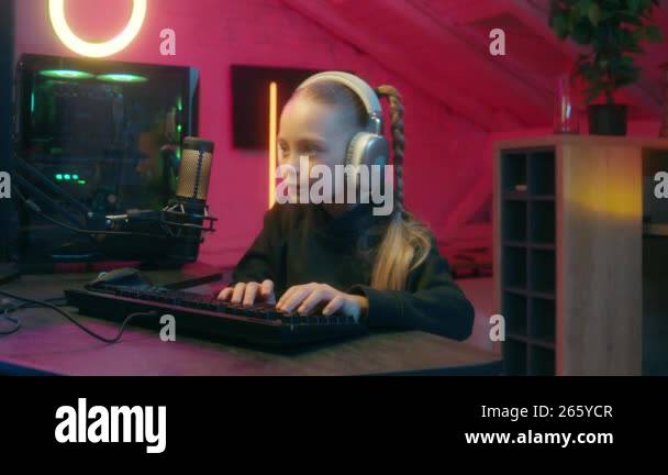 Concentrated gamer little girl user enjoy late evening streaming ...
