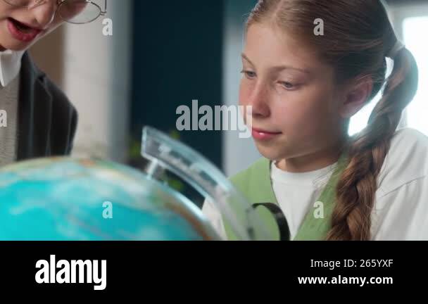 Studying geography Caucasian woman female professor teacher teaching little girl student school ...