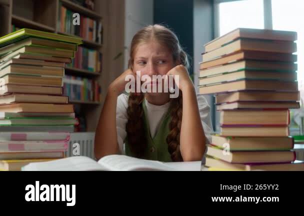 Suffering teenager upset Caucasian little girl shocked kid child looking at two large piles ...