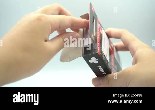 Taking out a deck of playing cards from the box with a white background ...
