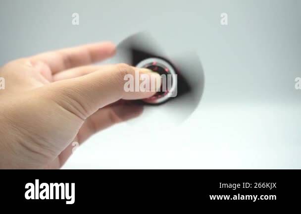 A hand spinning a fidget spinner toy on a white background Stock Video ...