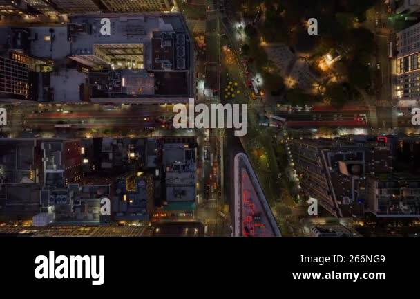 Tripod view from a unique crane perspective of traffic on a busy intersection at night in New ...