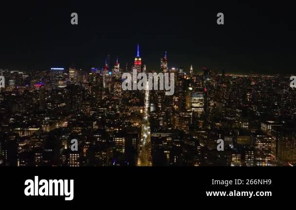 Aerial views capture Midtown Manhattan at night. Iconic Empire State ...