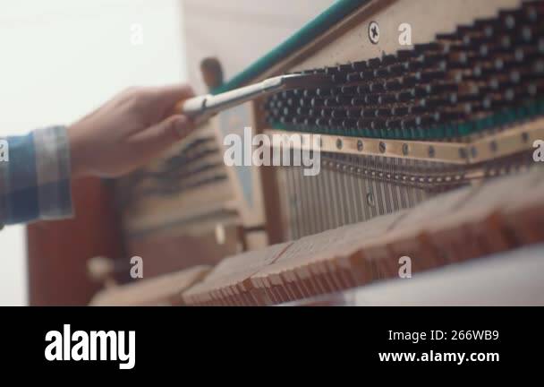 A man's hand tuning a piano. Close-up of a piano tuning (repair). Piano ...