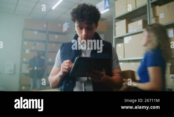 Male warehouse associate uses tablet computer and stylus. Sorting ...