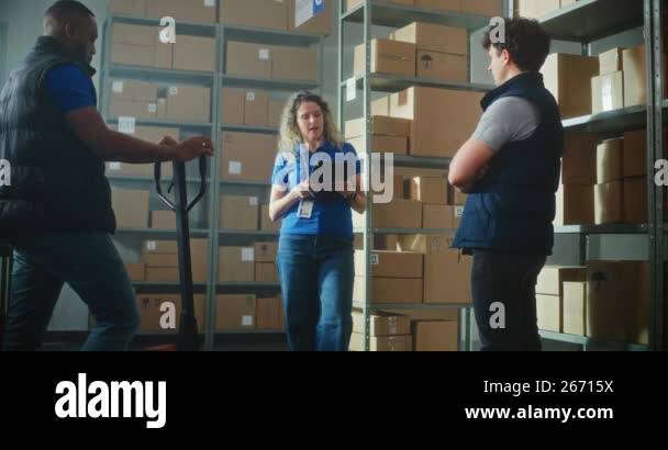 Female logistics supervisor with tablet computer talks to male colleagues, gives instructions ...