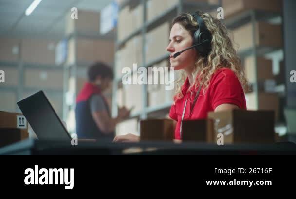 Female logistics coordinator wearing headset chats with customer on ...