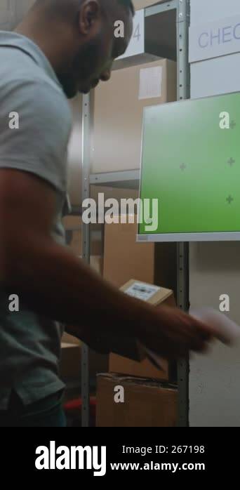 African American Warehouse Associate Scans Code on Cardboard Box with Scanner, Checks Parcel at ...
