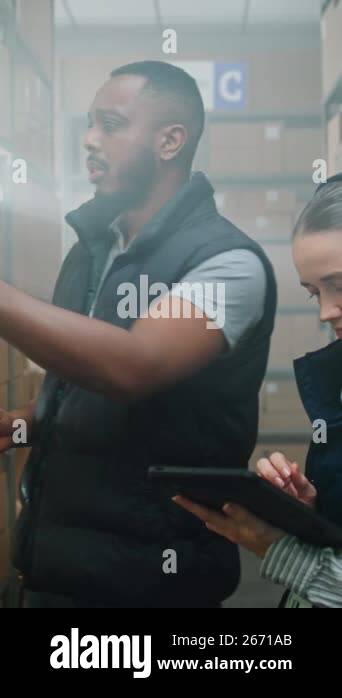 African American Sorting Center Worker Scans Cardboard Boxes with Orders Using Scanner. Female ...