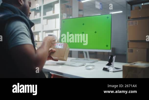 Delivery Service: African American Warehouse Associate Scans Code on Cardboard Box with Scanner ...