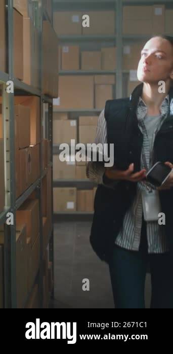 Female Warehouse Associate Scans Cardboard Box with E-Commerce Goods with Scanner, Checks ...