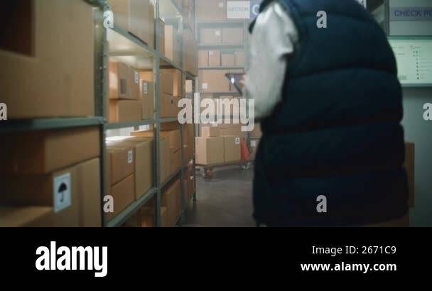 Female Manager Wearing Headset Walks, Uses Tablet Computer. African American Sorting Worker ...