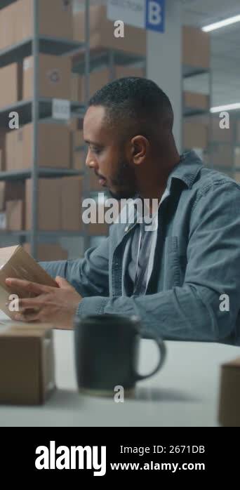 Postal service: African American logistics specialist scans parcel with ...