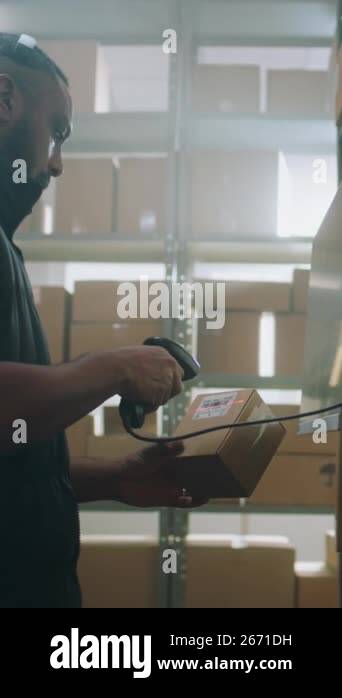 African American Logistics Manager Scans Cardboard Box at Postal Terminal with Digital Screen ...