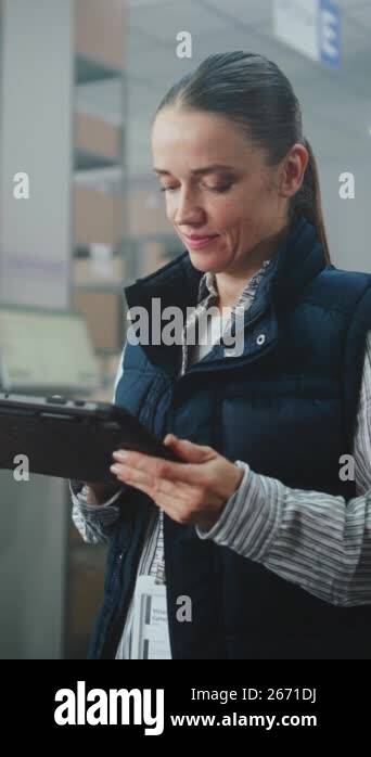 Female Inventory Manager in Warehouse Facility: Uses Tablet Computer ...