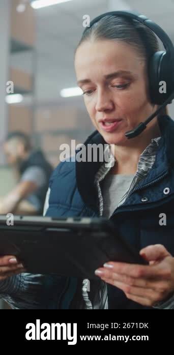 Female Customer Support Specialist in Logistics in Headset Talks on Call with Client, Uses ...