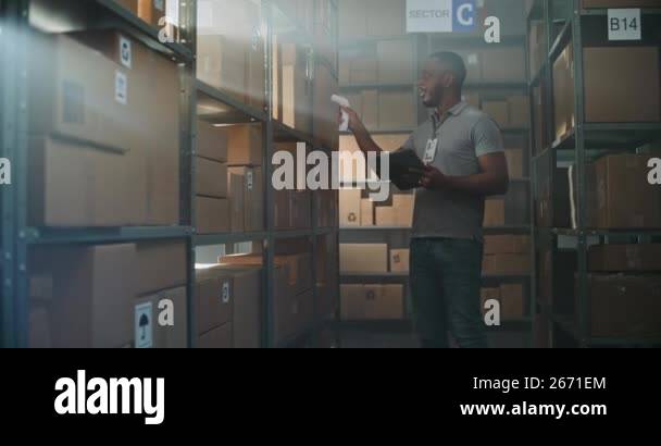 African American Warehouse Associate Scans Cardboard Boxes with Scanner, Checks Information on ...