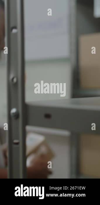 African American Warehouse Employee Scans Cardboard Box at Postal Terminal with Digital Screen ...