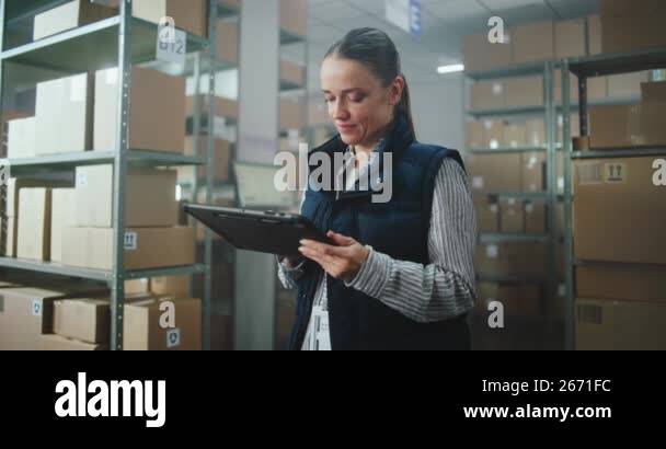 Female Inventory Manager in Warehouse Facility: Uses Tablet Computer ...